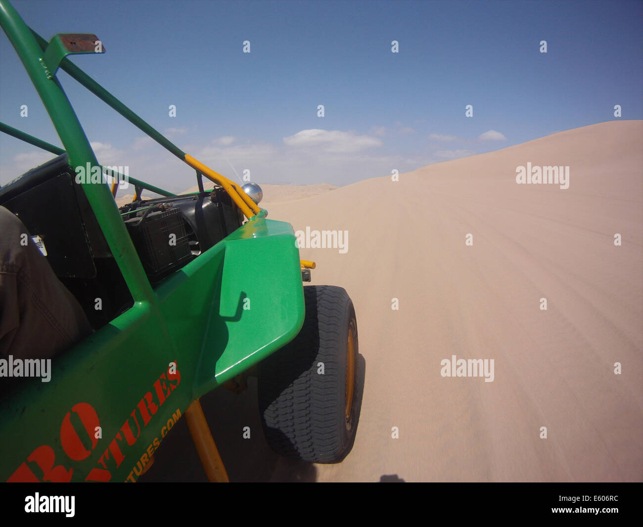 A 4 wheel drive buggy races through the sand dunes of the desert near ...