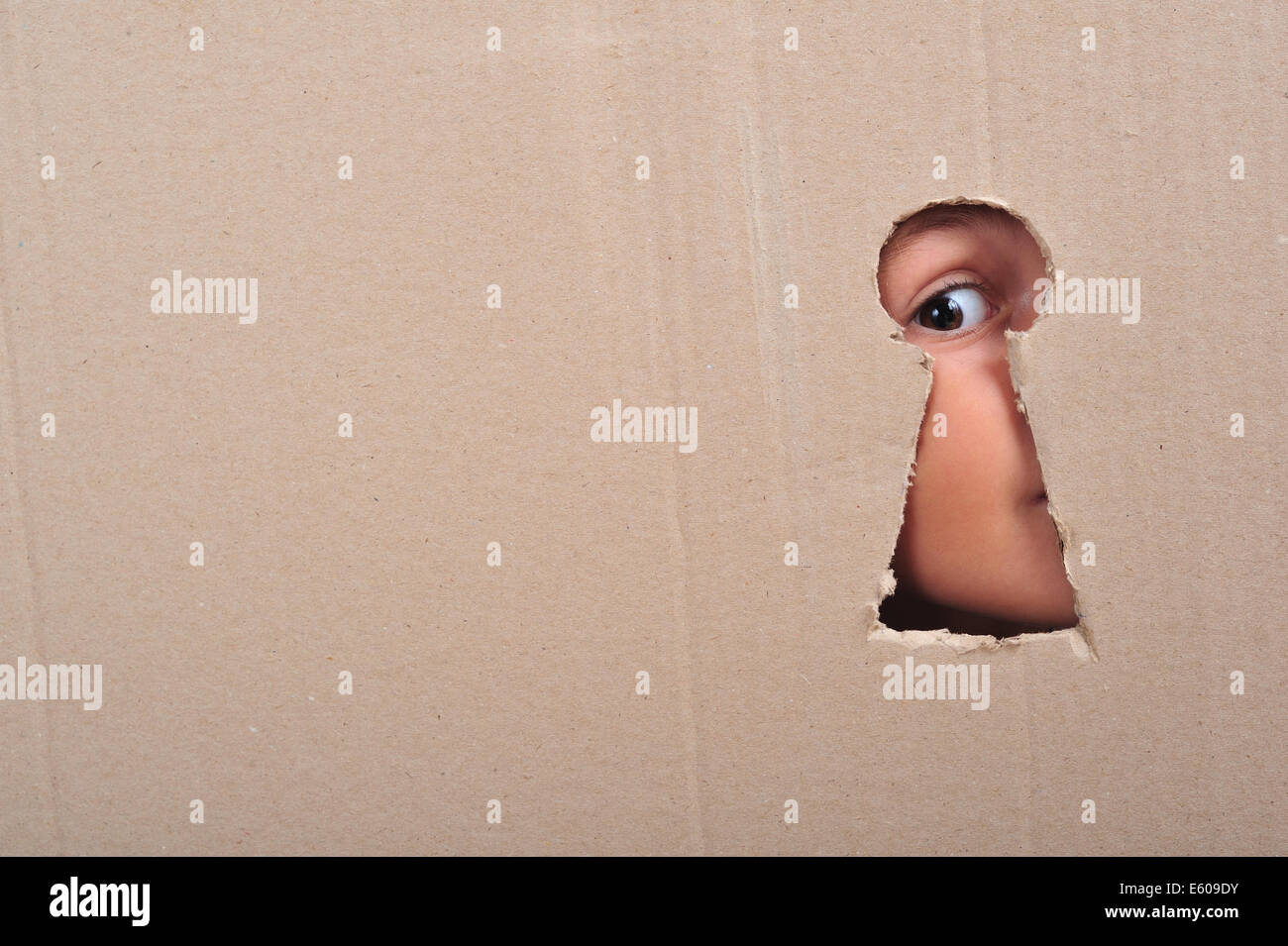 Eye looking through a conceptual keyhole on cardboard close up Stock ...
