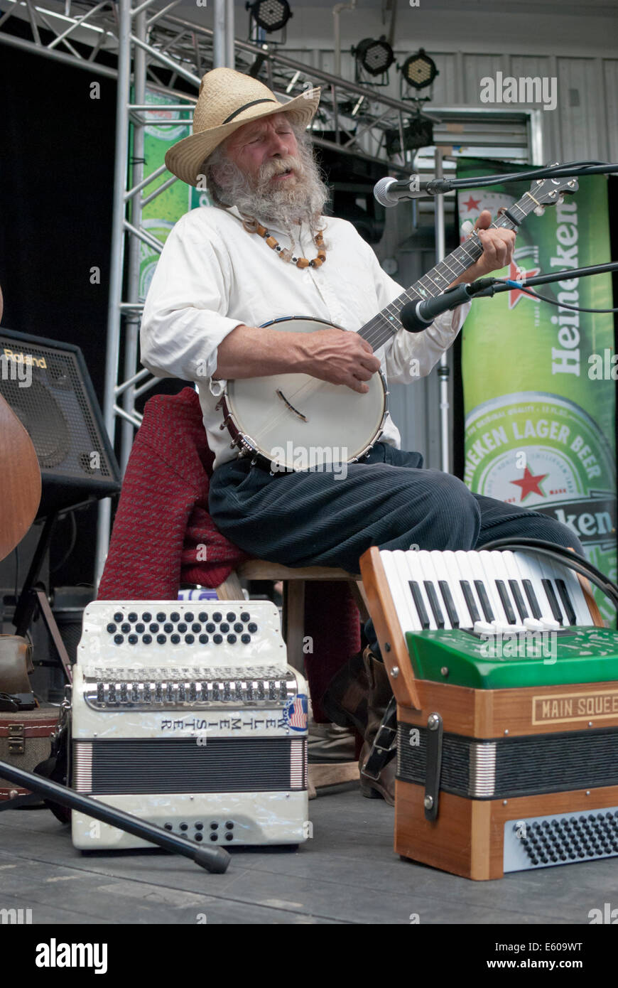 A local musician plays the banjo and accordions at the farmers market ...