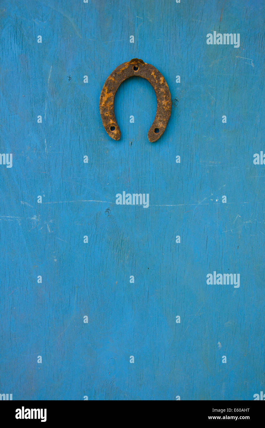 luck symbol old rusty horseshoe on blue wooden wall Stock Photo - Alamy