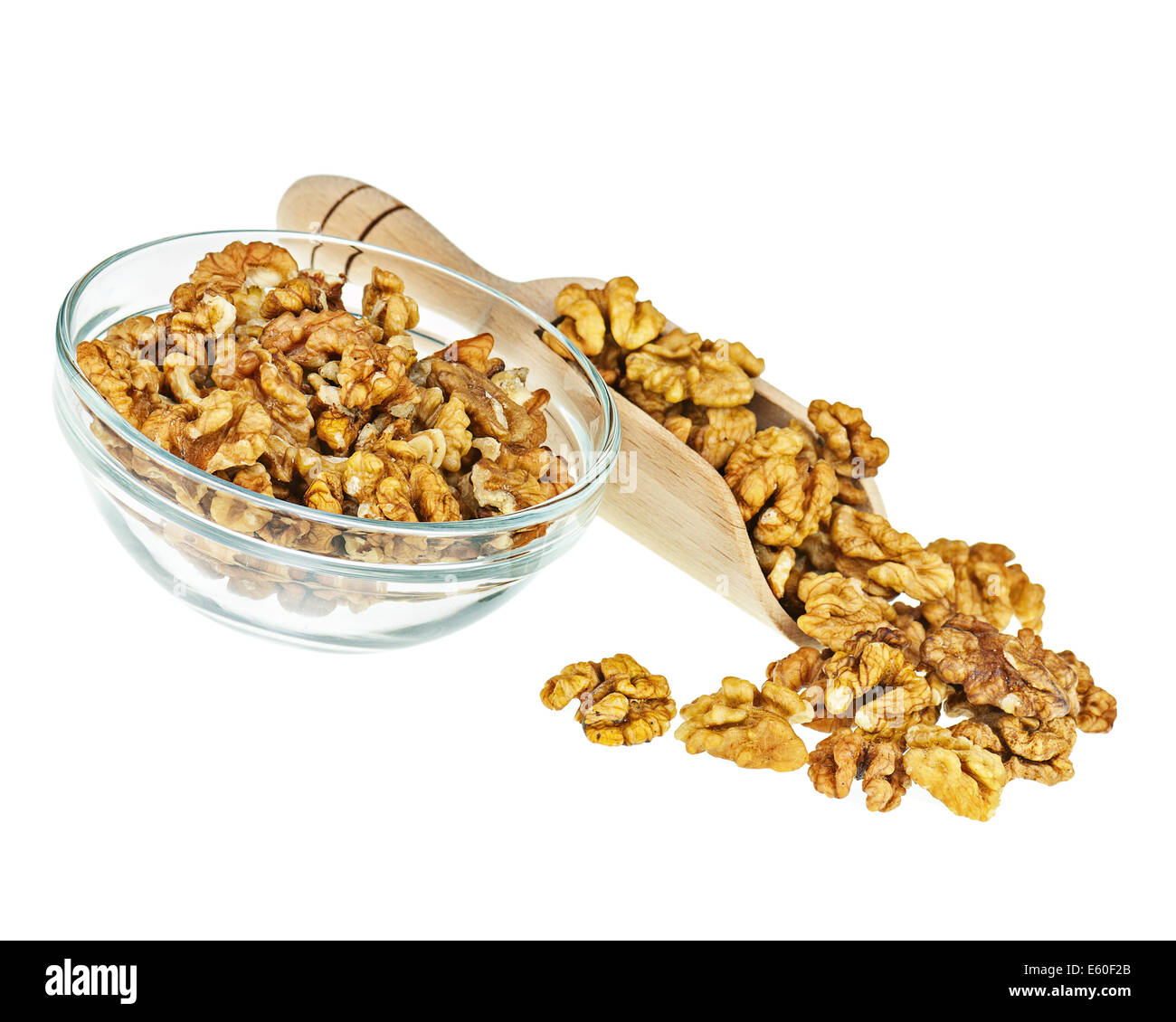 Handful of walnuts in scoop and glass bowl isolated on white background ...