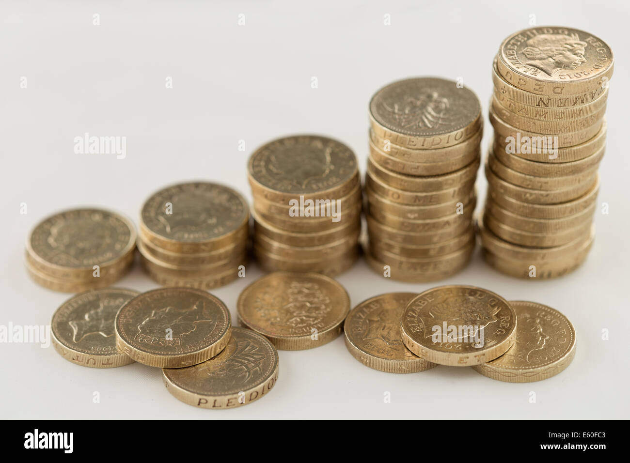 Ascending stacks of pound sterling coins against a white background ...