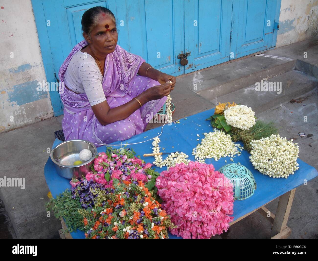 A Hindu lady prepares cut flowers on a stall at the Kapaleeshwar Temple ...