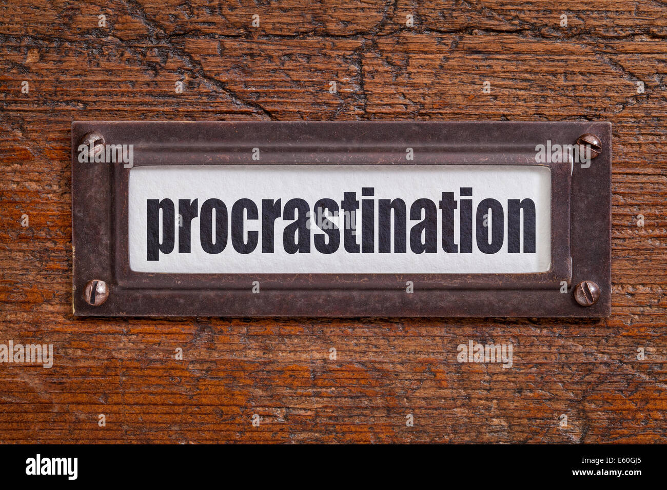 procrastination word - file cabinet label, bronze holder against grunge ...