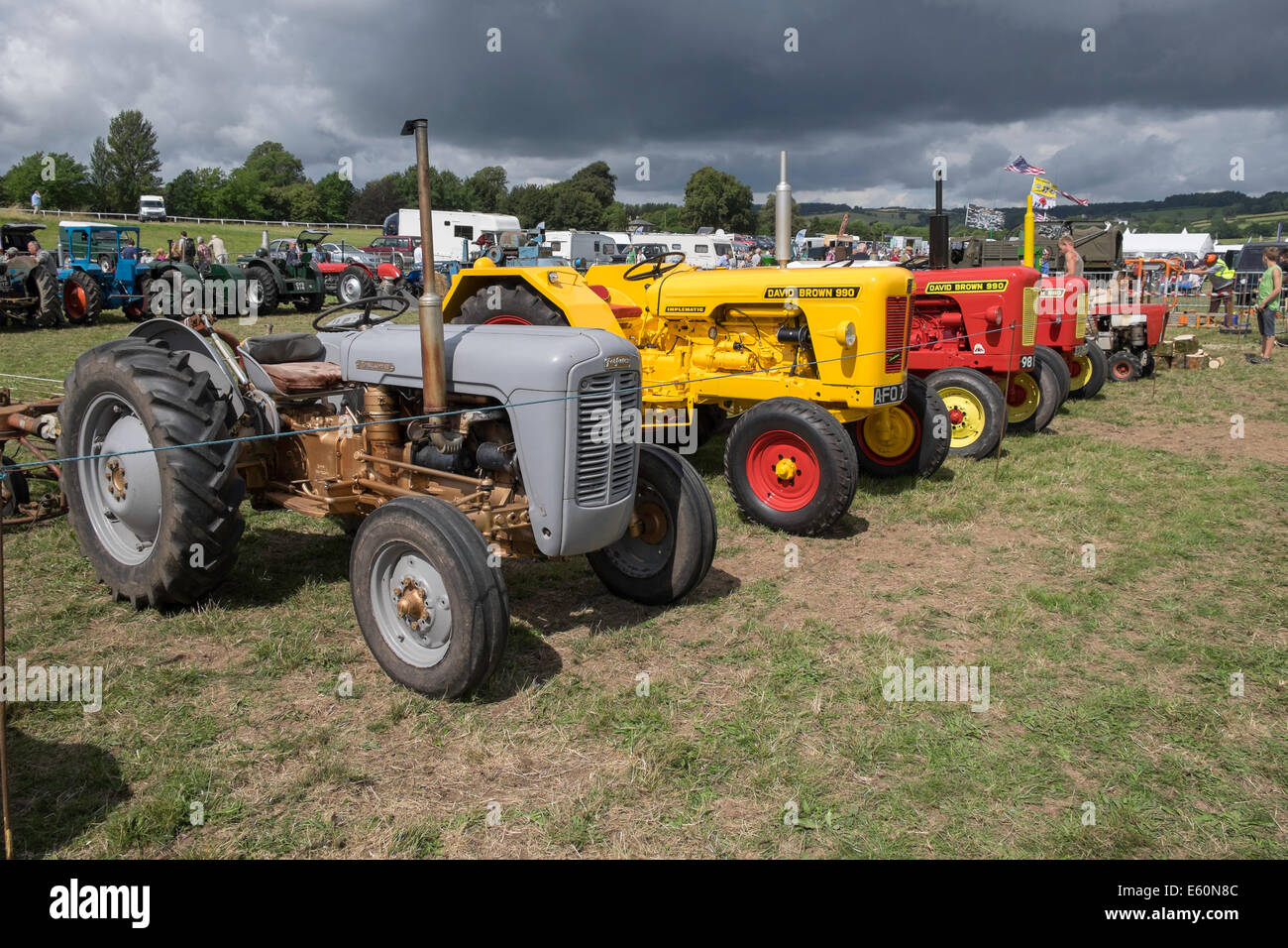 LINE-UP OF OLD TRACTORS AT AGRICULTURAL SHOW UNDER STORMY SKY IN ...