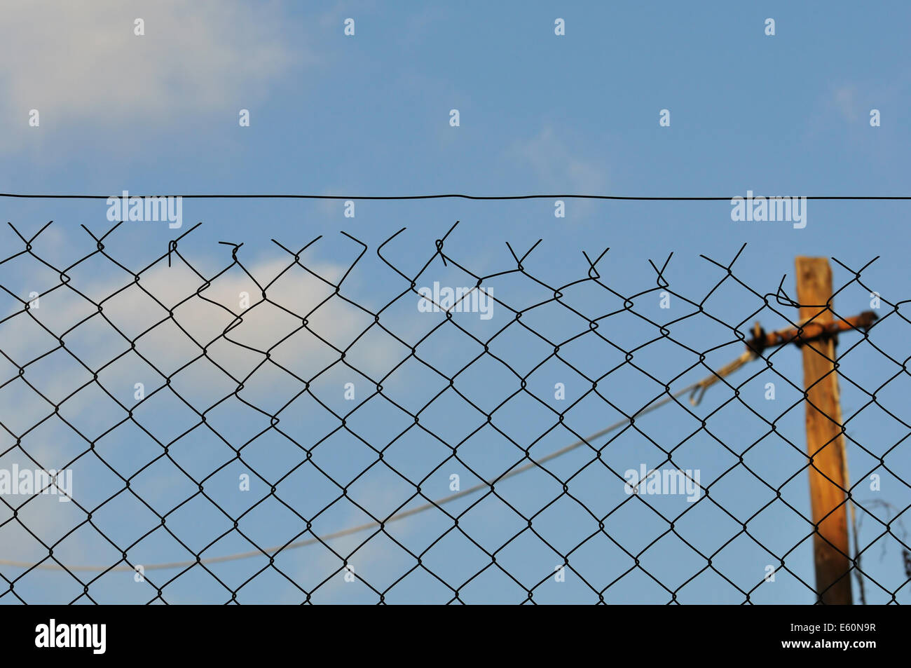 Chain link fence and blue sky urban background Stock Photo - Alamy