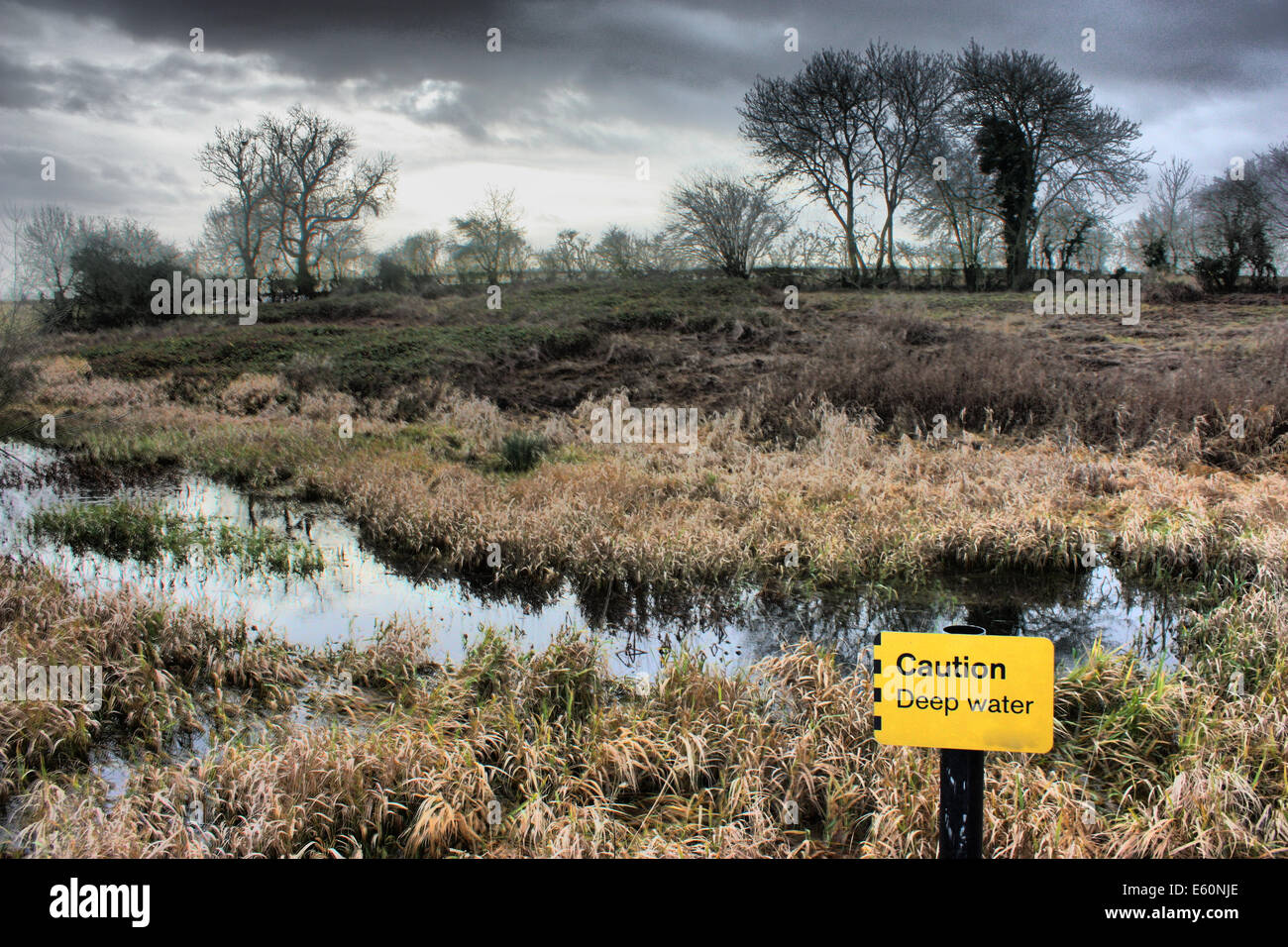 yellow caution deep water sign in front of a marsh Stock Photo - Alamy