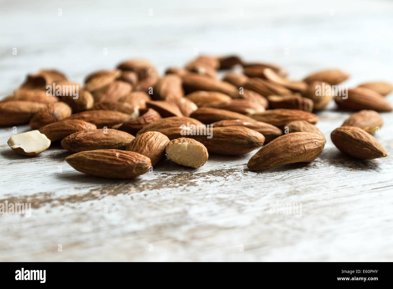 Many almonds over a wooden table, background Stock Photo - Alamy