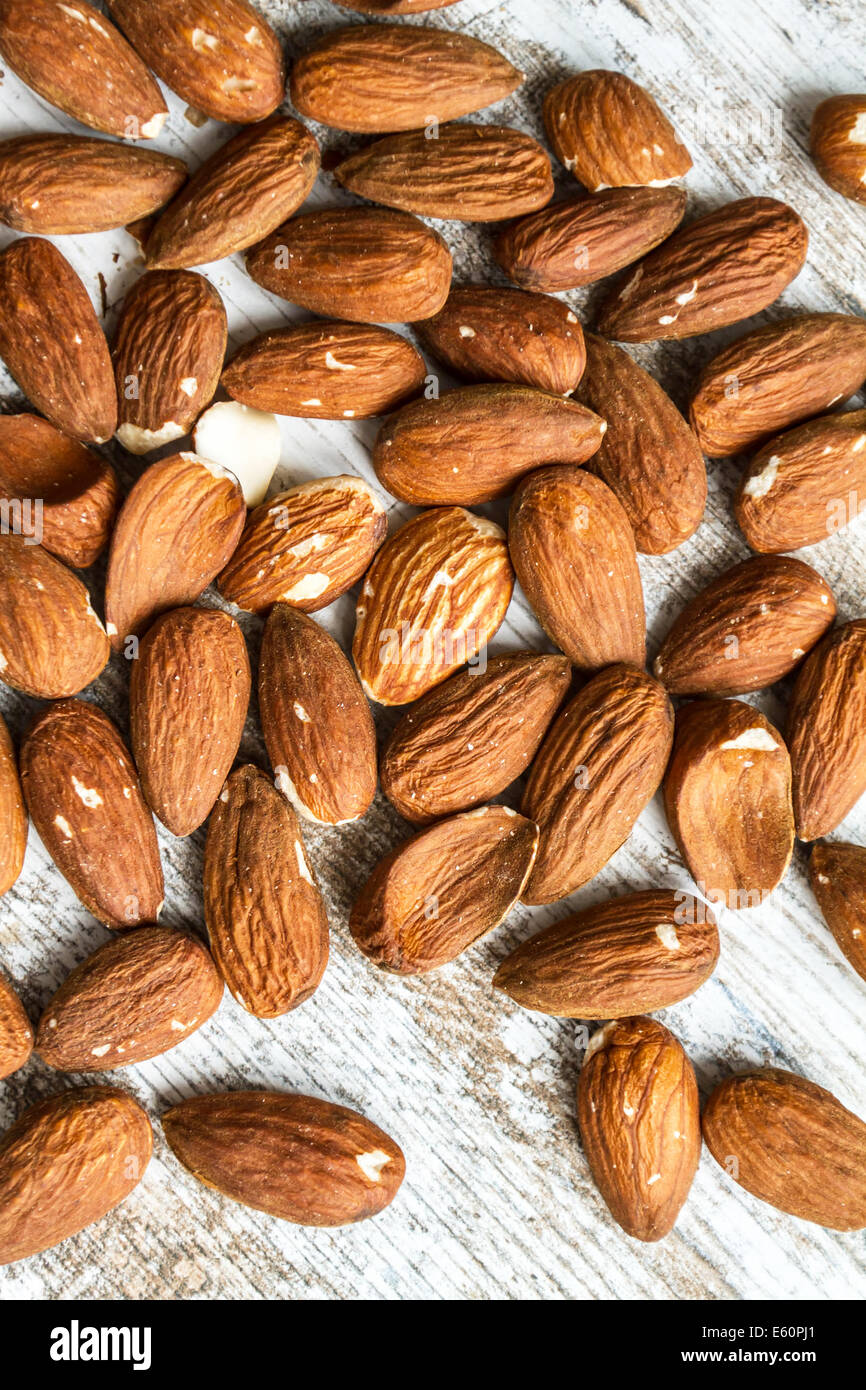 Many almonds over a wooden table, background Stock Photo - Alamy