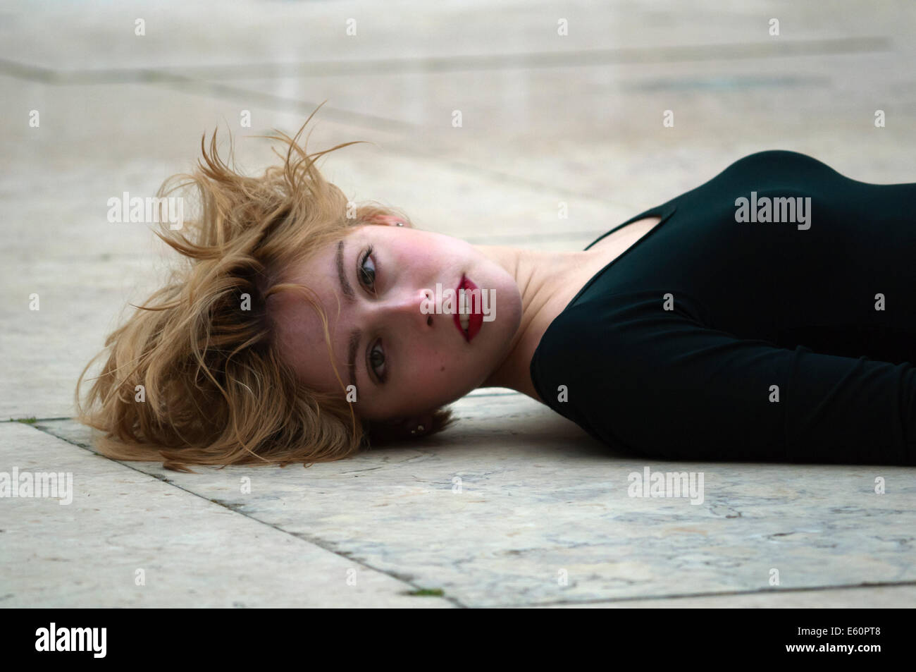 Young woman lying on the ground Stock Photo - Alamy
