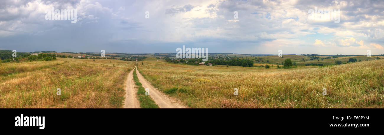 Countryside landscape panorama with cottages on the hills and stormy ...