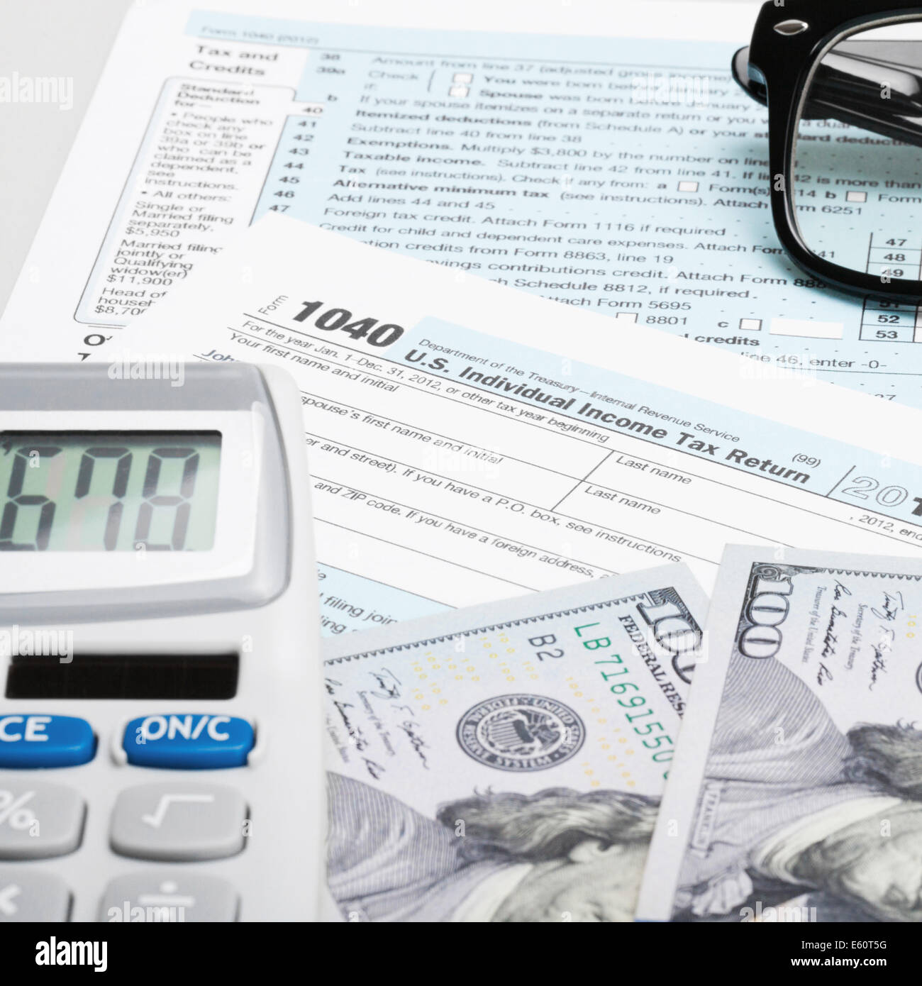 USA Tax Form 1040 with glasses, calculator and 100 US dollar bills ...