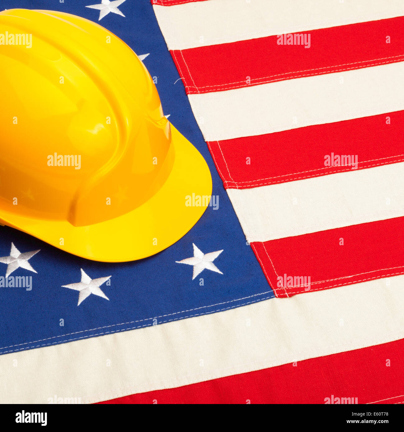 Yellow color construction helmet laying over USA flag - studio shoot ...
