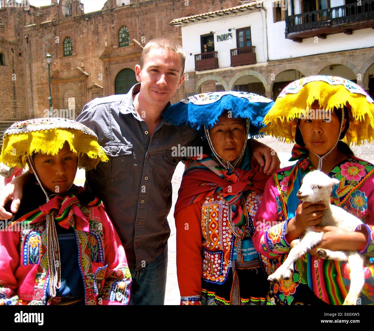 A tourist poses for a photo with a group of native Quechua ladies in ...