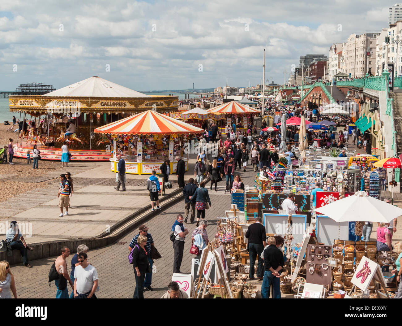 A jolly crowd of holidaymakers enjoy a walk along Brighton's seafront ...