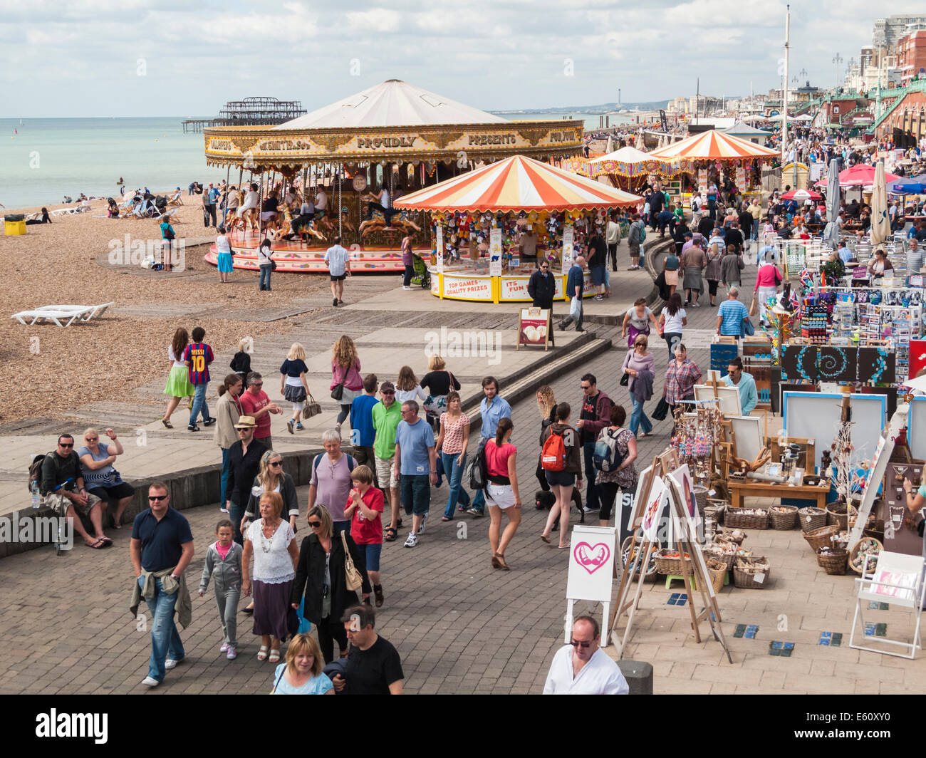 A jolly crowd of holidaymakers enjoy a walk along Brighton's seafront ...