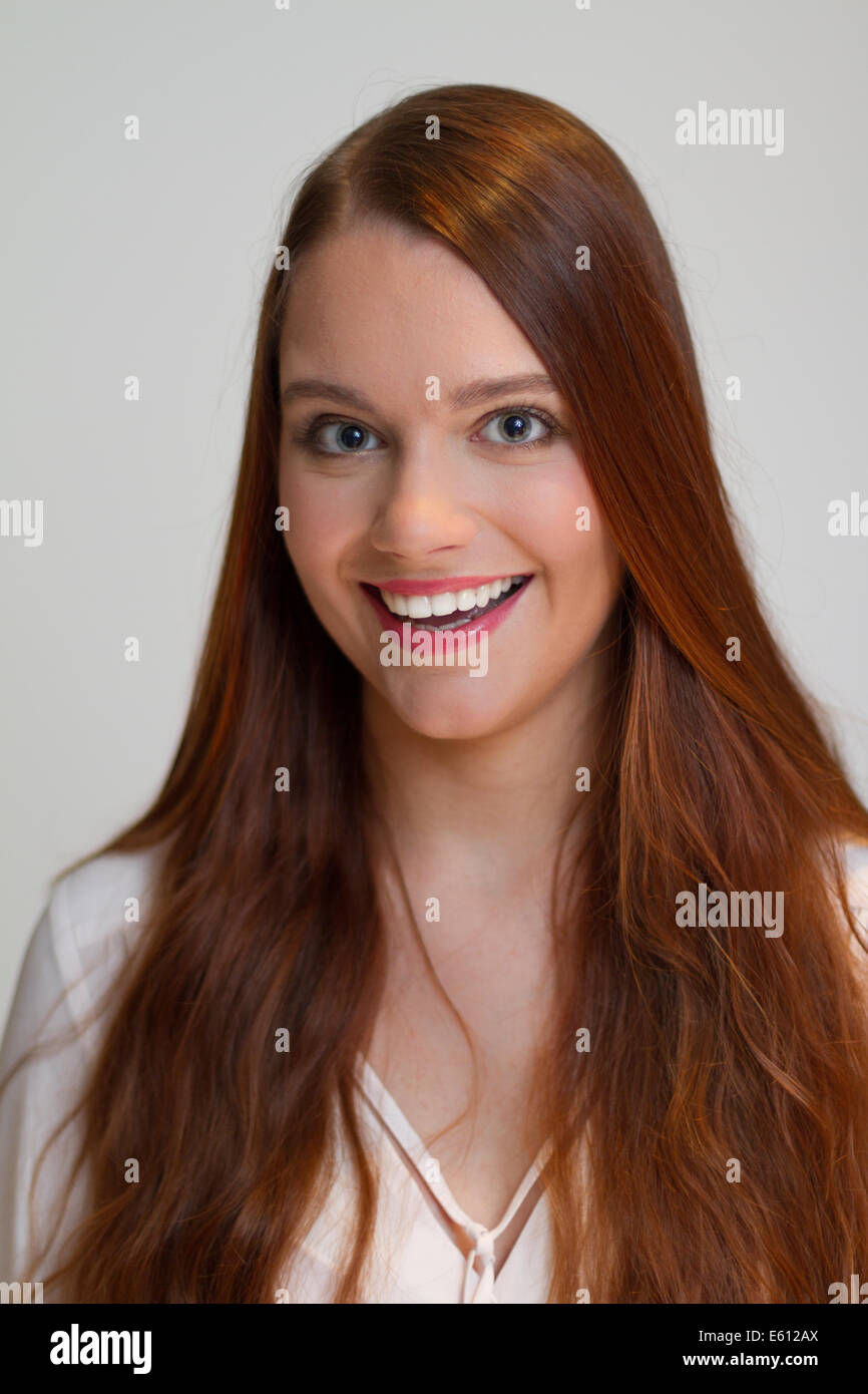 Portrait of a young redhead woman smiling on a white background Stock ...