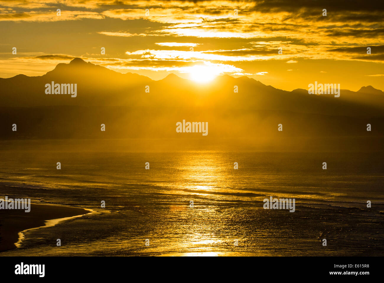 Sunrise on the coast of the Indian Ocean, reflections of sun rays in ...
