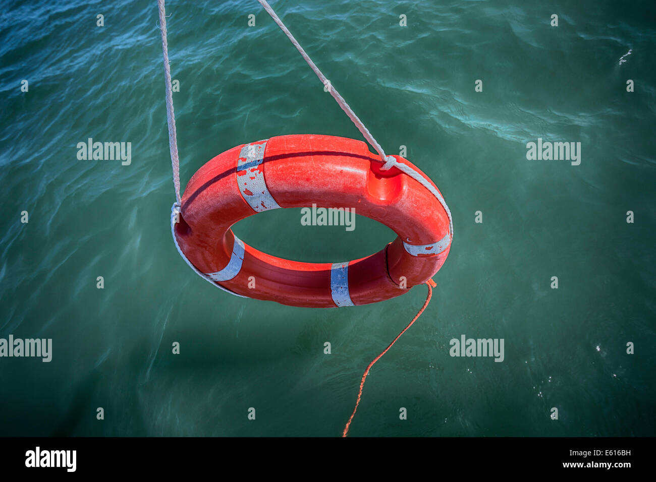 Lifebuoy dangling over water Stock Photo - Alamy