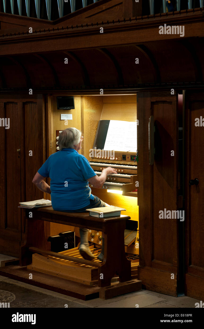 A woman playing the organ in St. Michael and All Angels Church, Ledbury ...