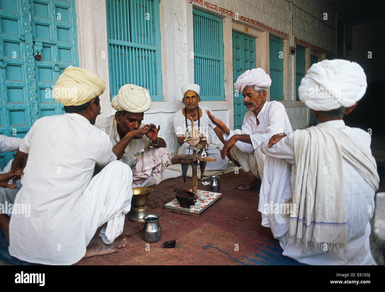 Traditional opium ceremony. A man is drinking a concoction made from ...