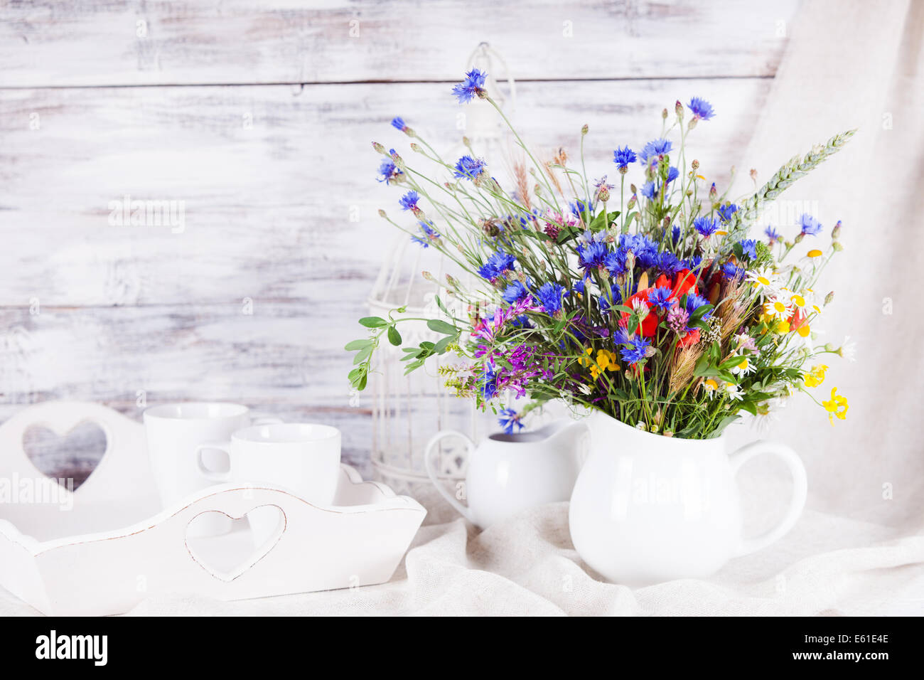 Wildflowers in white ceramic jug and cups on tray Stock Photo - Alamy
