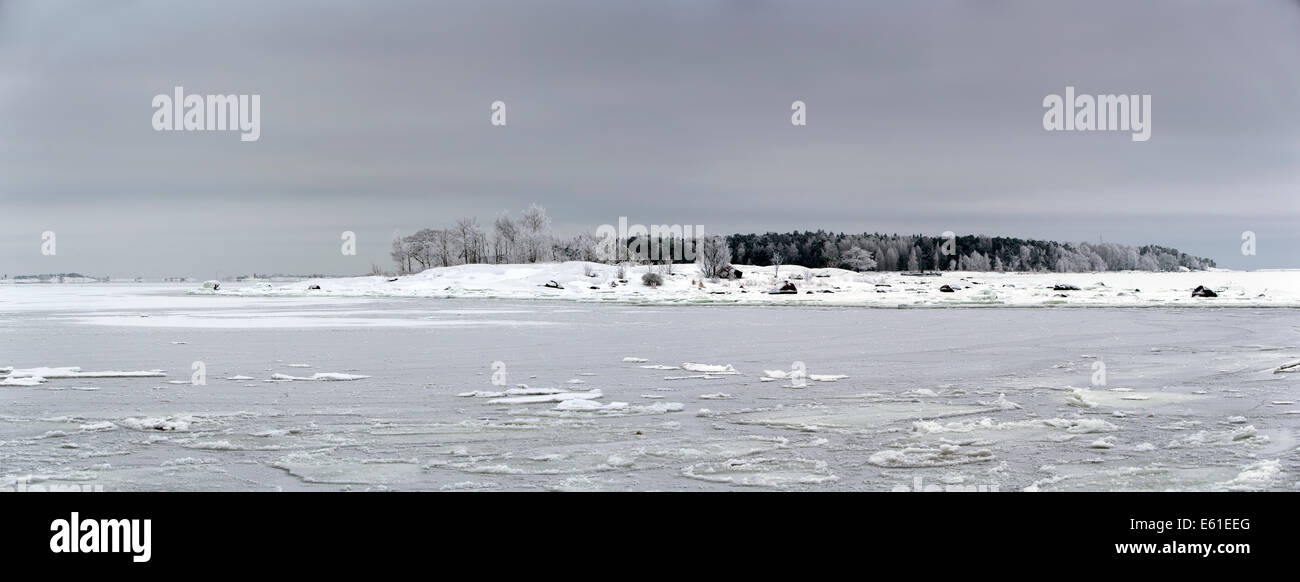 A frozen seascape with an island in the background with snow and frost ...