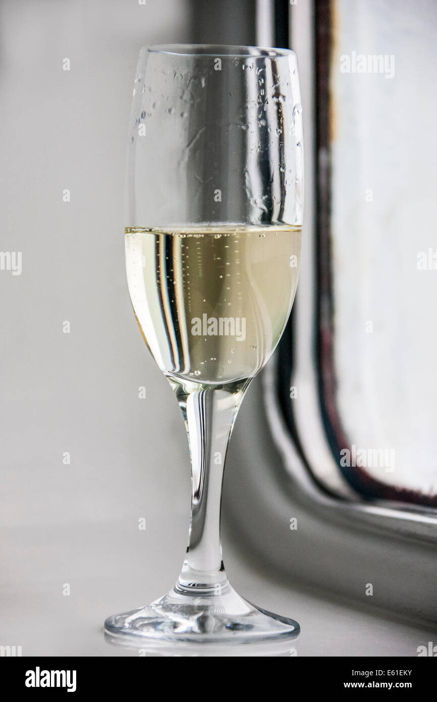 A champagne flute half filled or half empty with champagne resting on ...