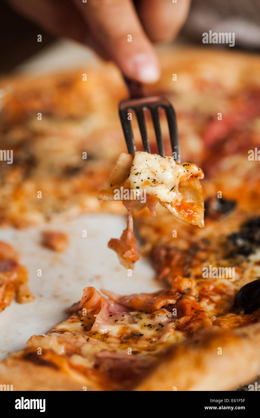 Man eats pizza. Close up pizza with fork and knife Stock Photo - Alamy