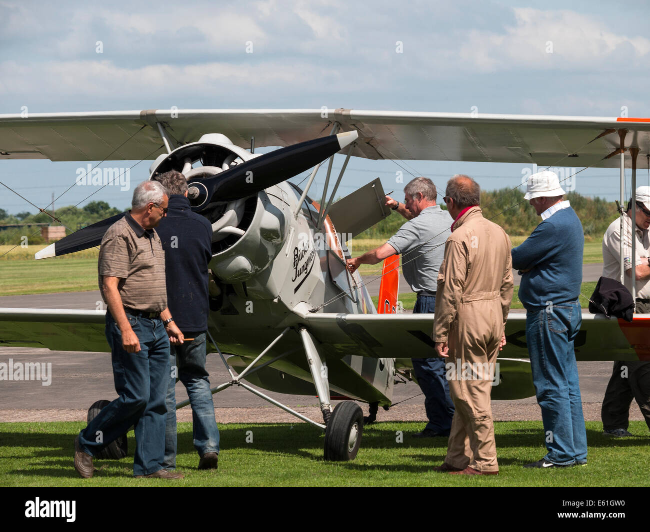 pilots gather round a 1930's Bucker Jungmann biplane aerobatic aircraft ...