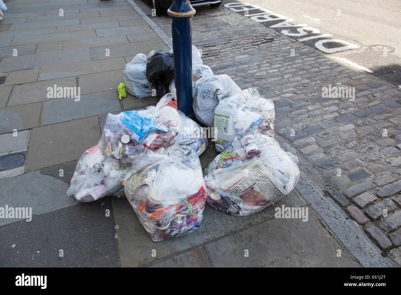 Rubbish in bags on the pavement awaiting collection Stock Photo - Alamy