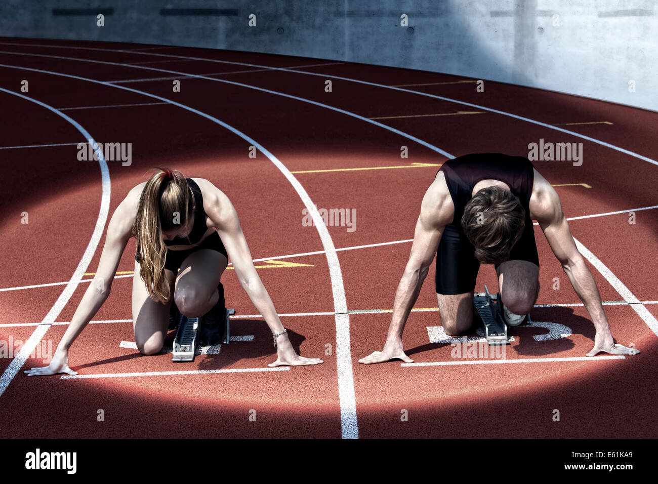 Sprinter couple in start position illuminated by a spotlight Stock ...
