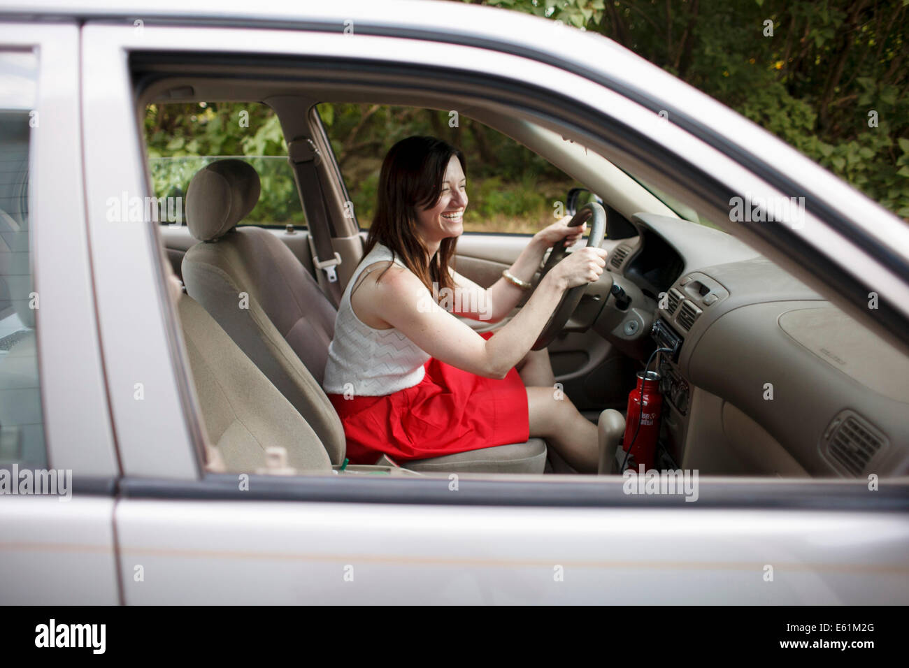 Smiling Woman Sitting Behind Steering Wheel in Car Stock Photo - Alamy