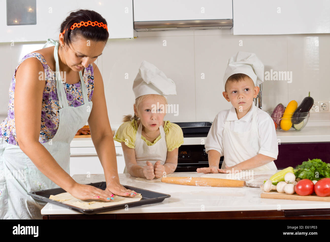 Mother Helping Chef Kids Making Food at the Kitchen Stock Photo - Alamy