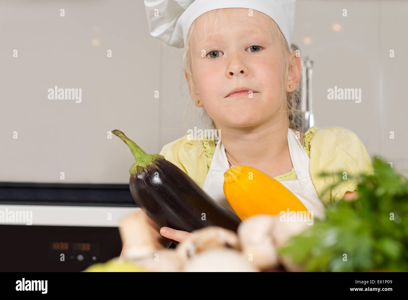 Little girl doing the cooking of the dinner selecting fresh ingredients ...