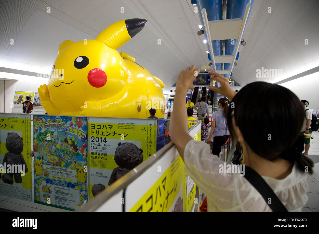 A visitor takes a picture of Pikachu at the "1000 Pikachu Outbreak! at ...