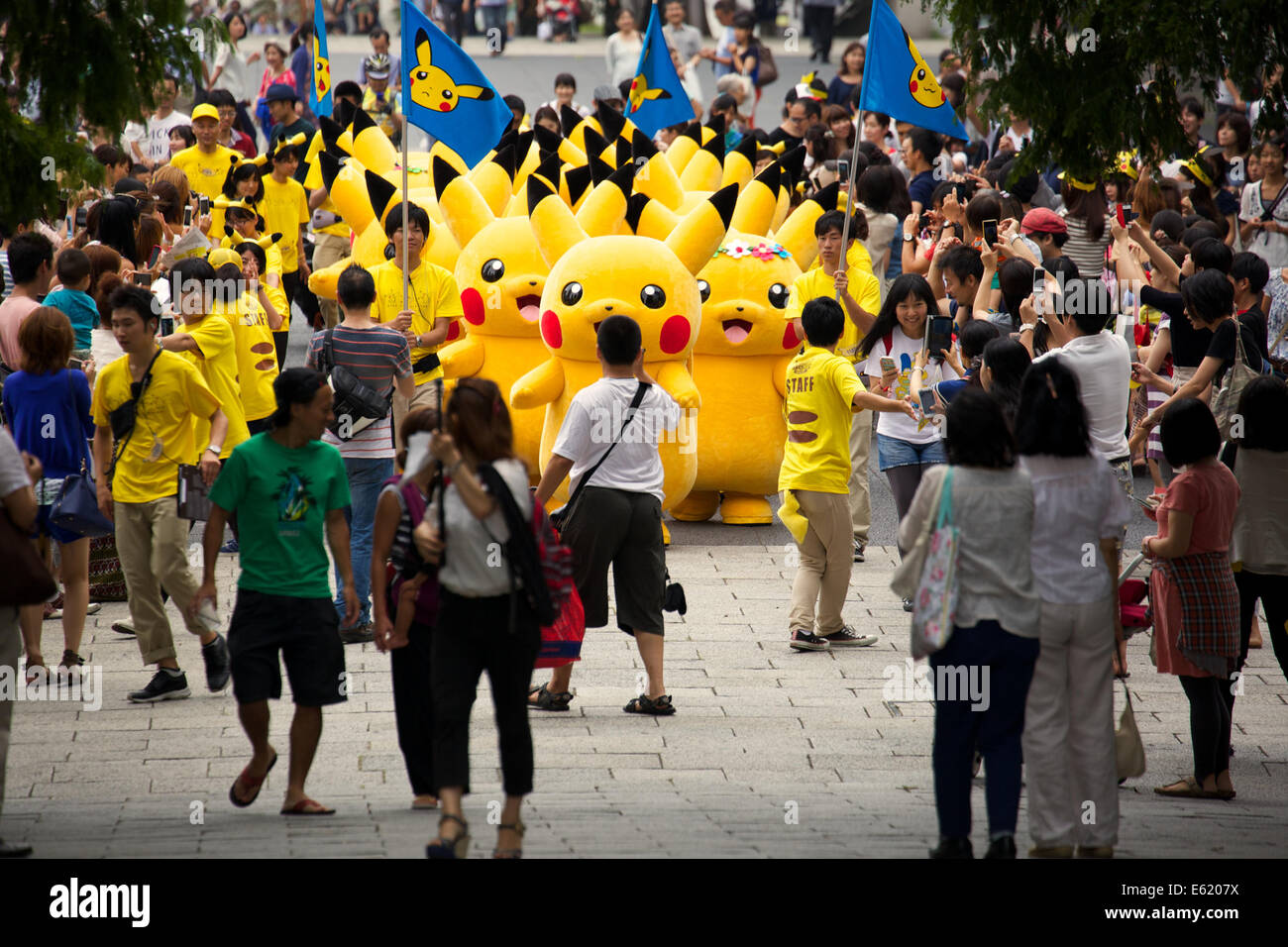 Visitors take pictures of 20 Pikachus marching on the street during the ...
