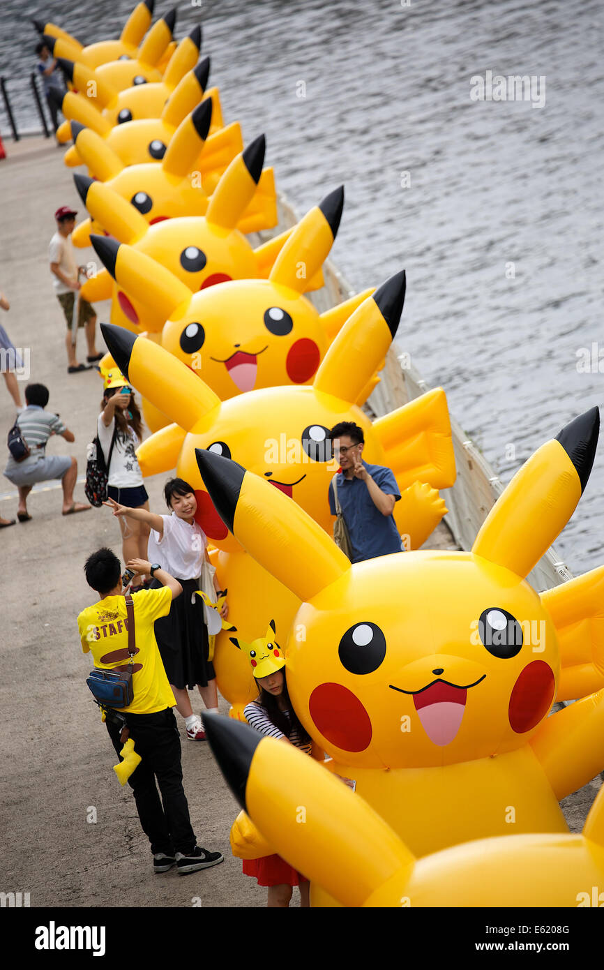 Visitors take pictures with the Pikachus at the "1000 Pikachu Outbreak ...