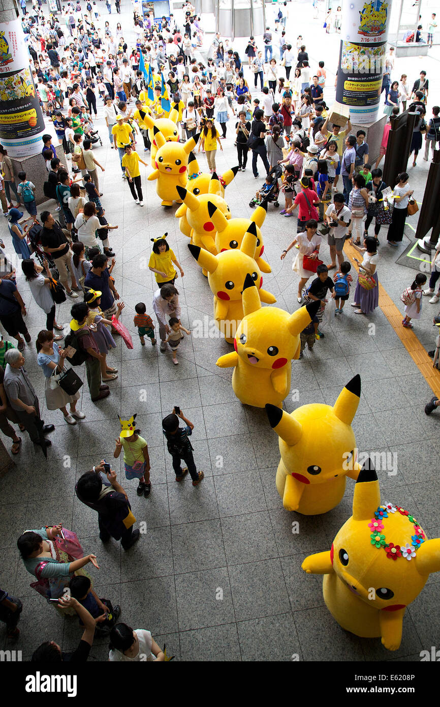 Visitors take pictures of the Pikachus marching on the street during ...