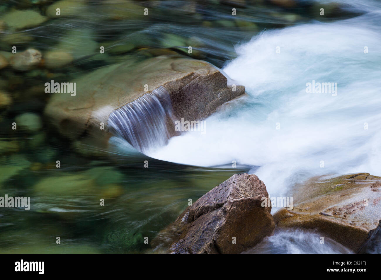 Abstract image of fast-flowing water moving over rocks through the ...