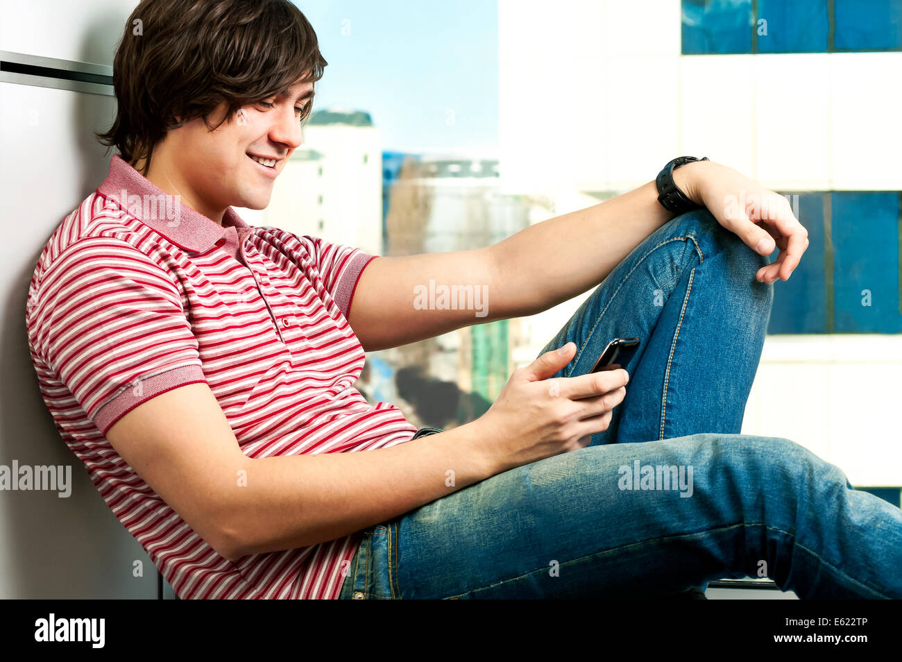 Smiling trendy young guy typing a message n mobile phone Stock Photo ... Smiling trendy young guy typing a message n mobile phone Stock Photo ...