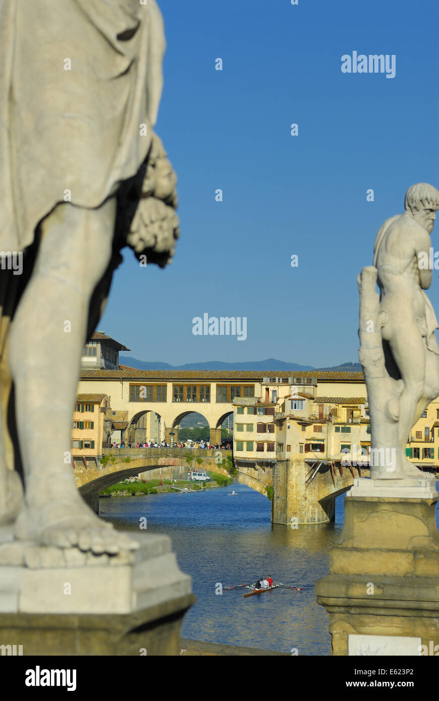 statues on bridge over River Arno overlooking Ponte Vecchio bridge ...