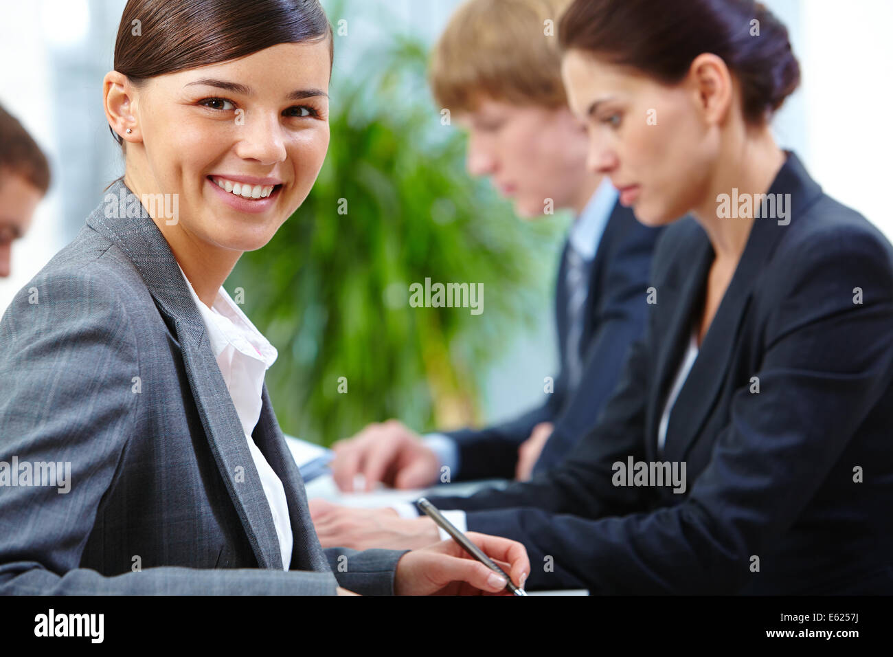 Portrait of happy employee looking at camera on the background of her ...