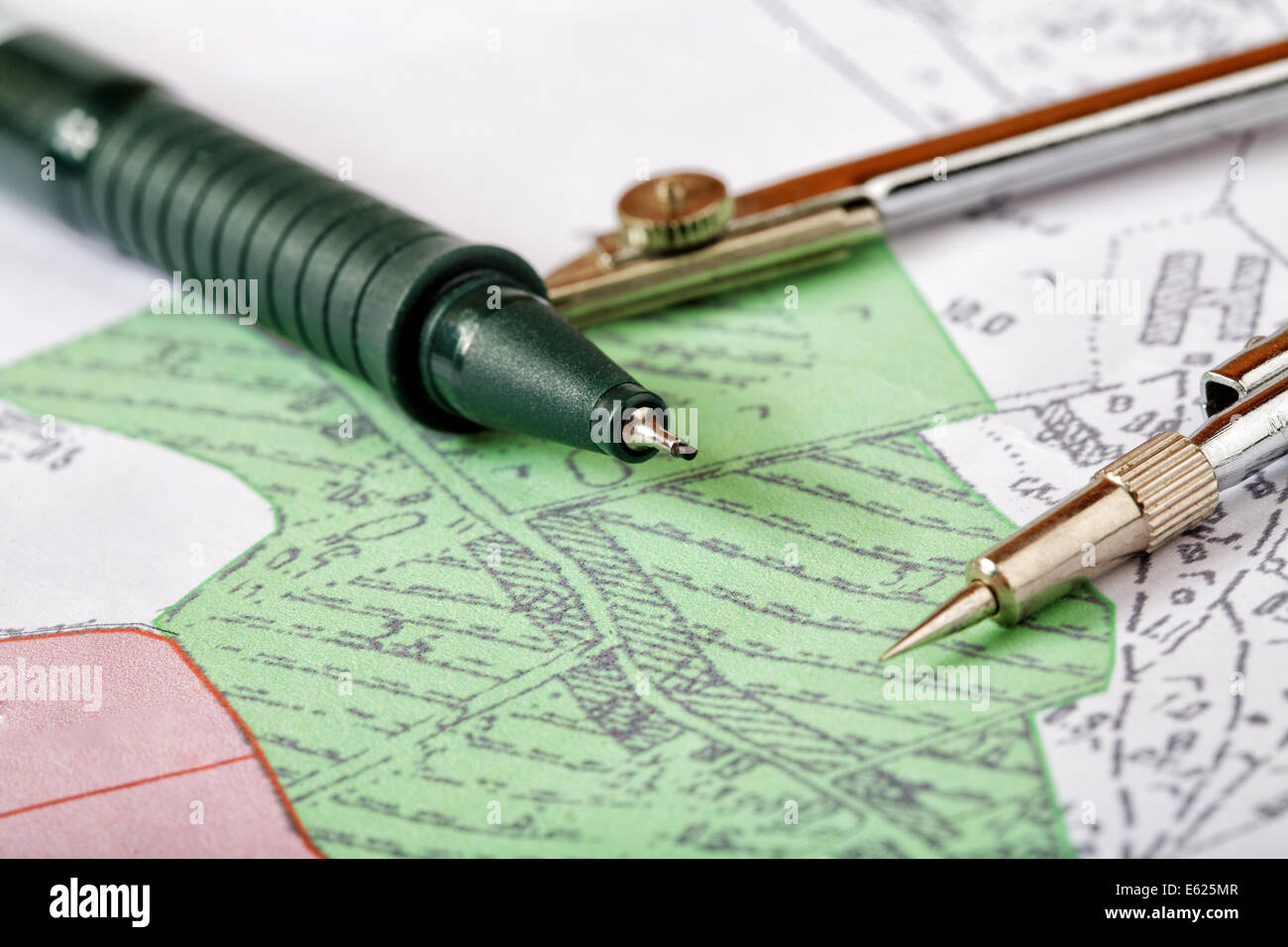 Topographic map of district with a measuring instrument and pencils ...