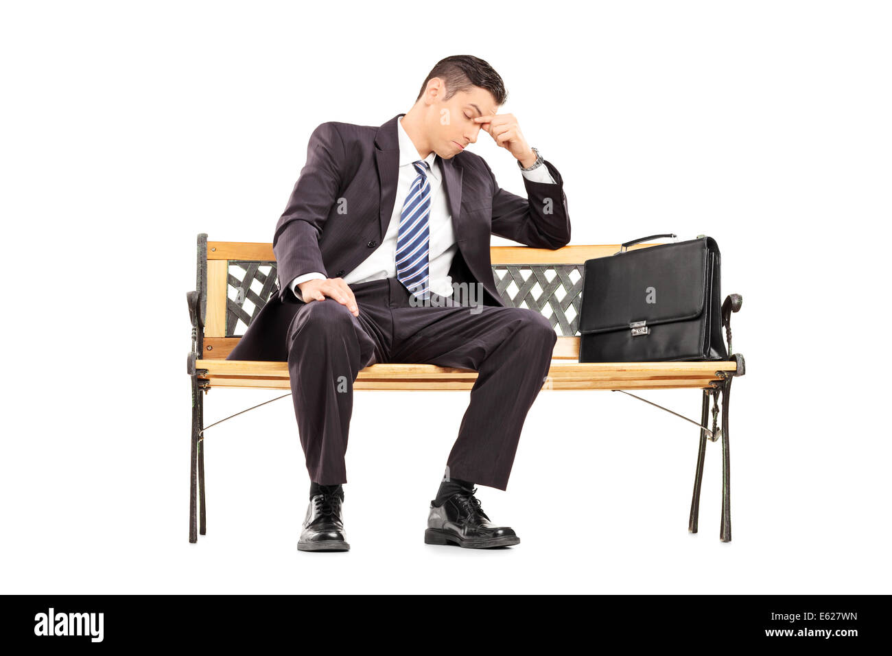 Tired businessman sitting on a bench Stock Photo - Alamy