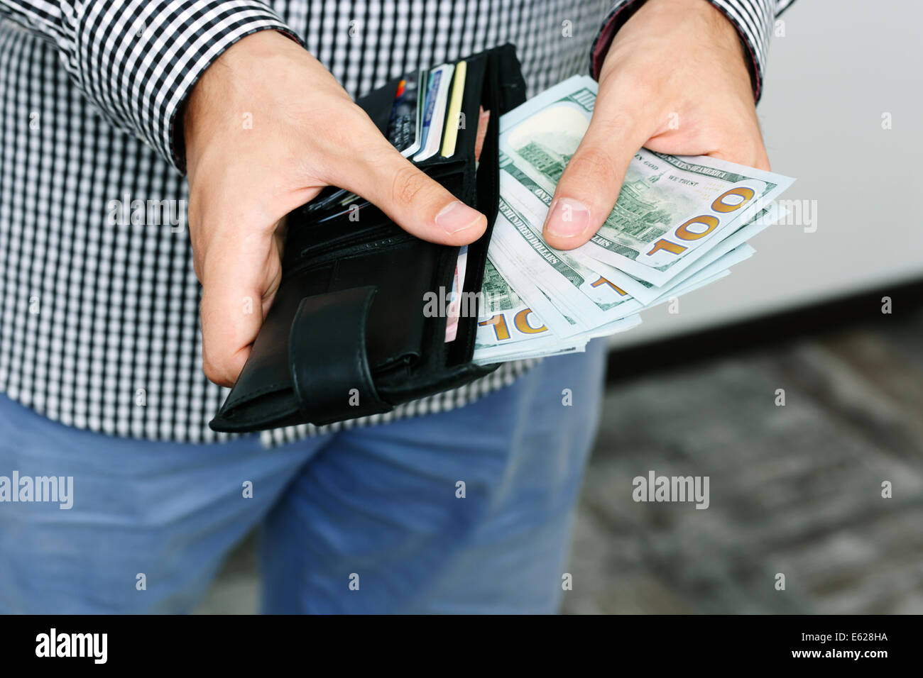 Hand pulling 100 dollars banknotes from wallet Stock Photo - Alamy