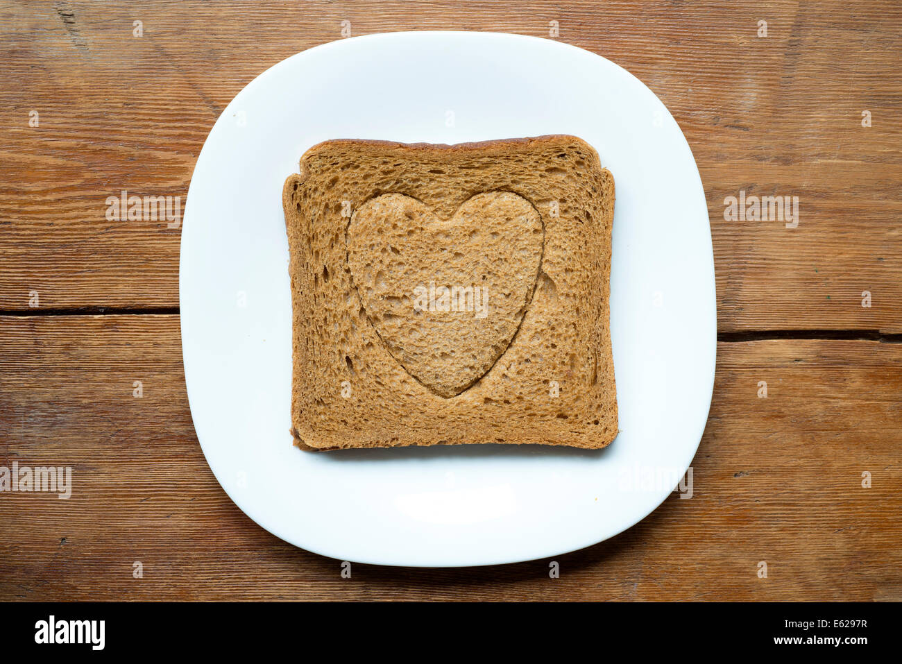 square grilled toast with heart symbol embossing on white plate Stock ...