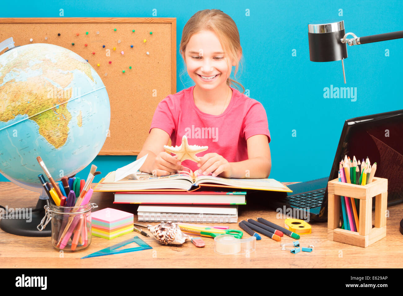 Young smiling girl doing her homework Stock Photo - Alamy