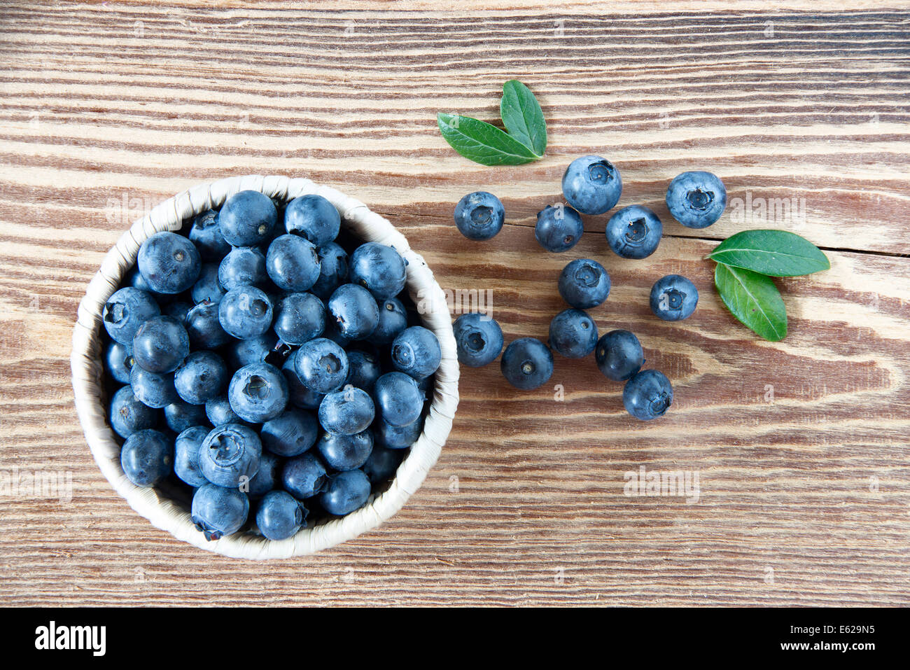 Fresh blueberries on a bowl and on a wooden table Stock Photo - Alamy