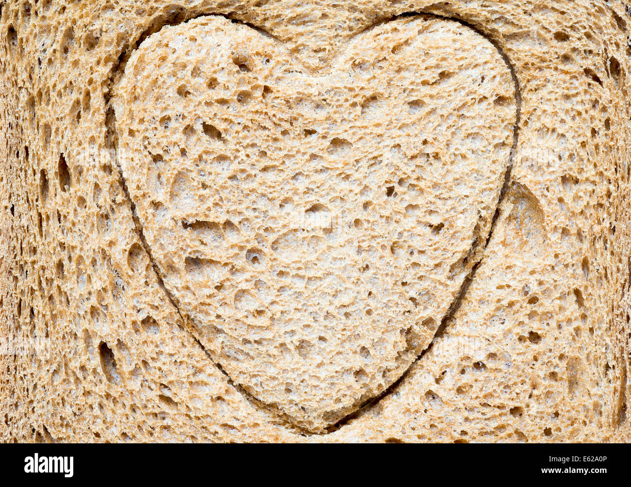 detailed surface of brown bread slice with embossed heart symbol Stock ...